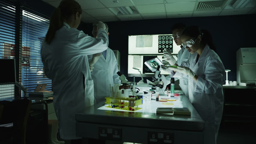 Diverse Team Of Scientists Or Researchers Working Together In A Dark ...