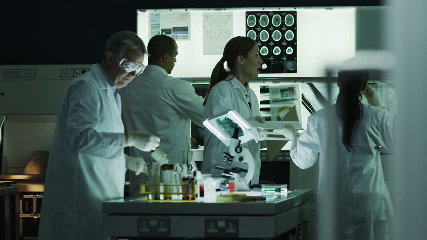 Diverse Team Of Scientists Or Researchers Working Together In A Dark ...