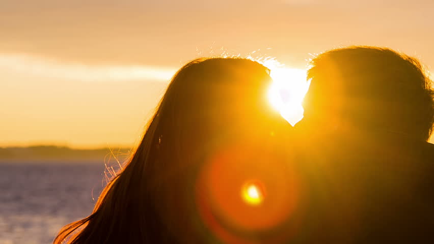 Romantic Young Couple Silhouette Is Kissing On A Sunset With Sun ...